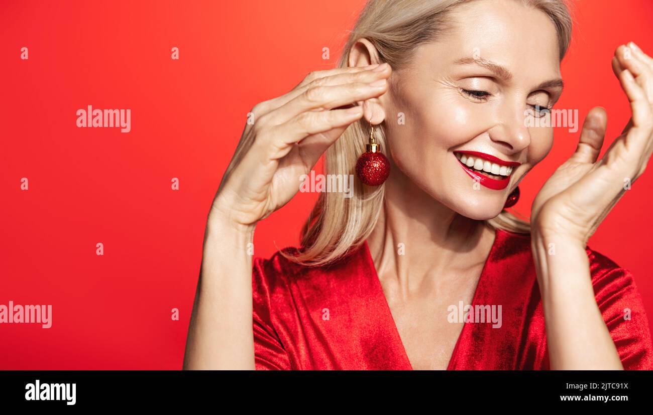 Gorgeous mature woman with red lips, holiday earrings and dress ...