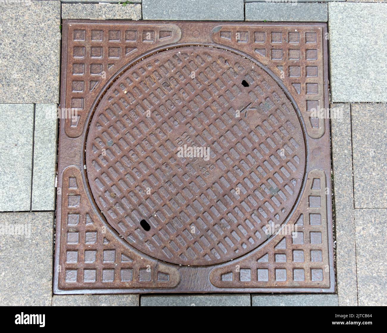 Old rusty sewer hatch on an old metal plate. View from above Stock ...