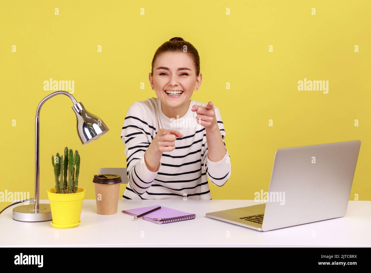 Optimistic woman office manager wearing striped shirt pointing to ...