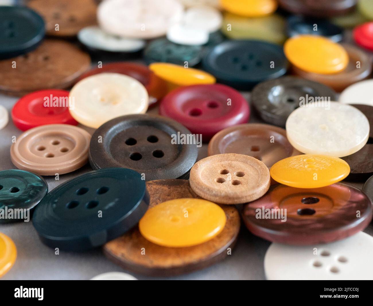 Round sewing buttons of different colours and sizes, close up. Variety ...
