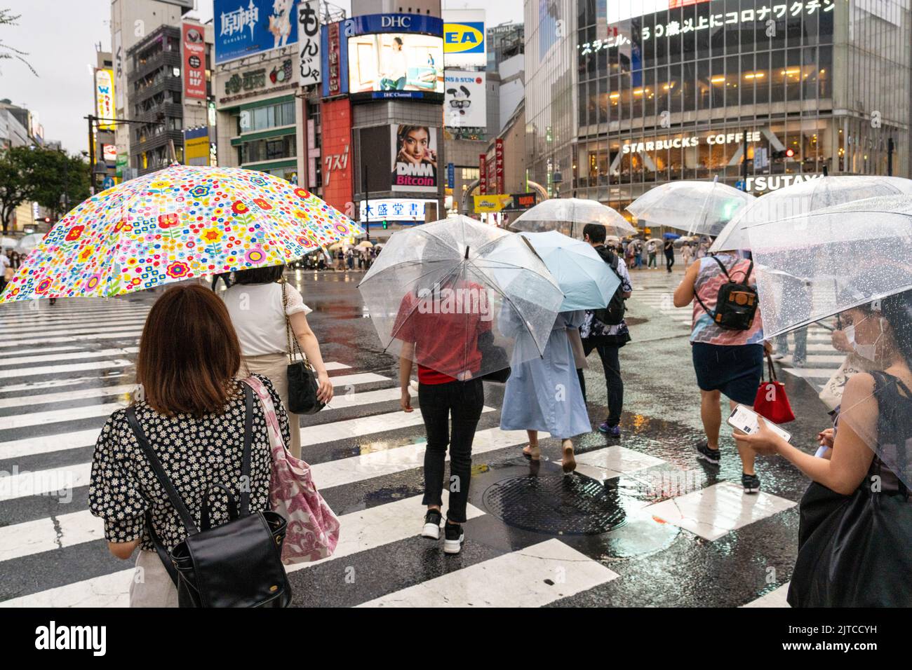 Pedestrians with umbrellas cross the multi-directional scramble ...