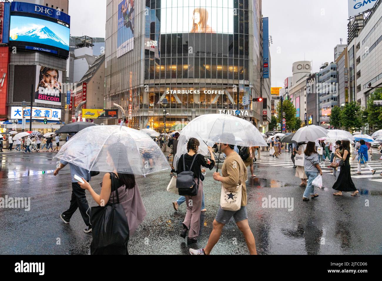 Pedestrians with umbrellas cross the multi-directional scramble ...
