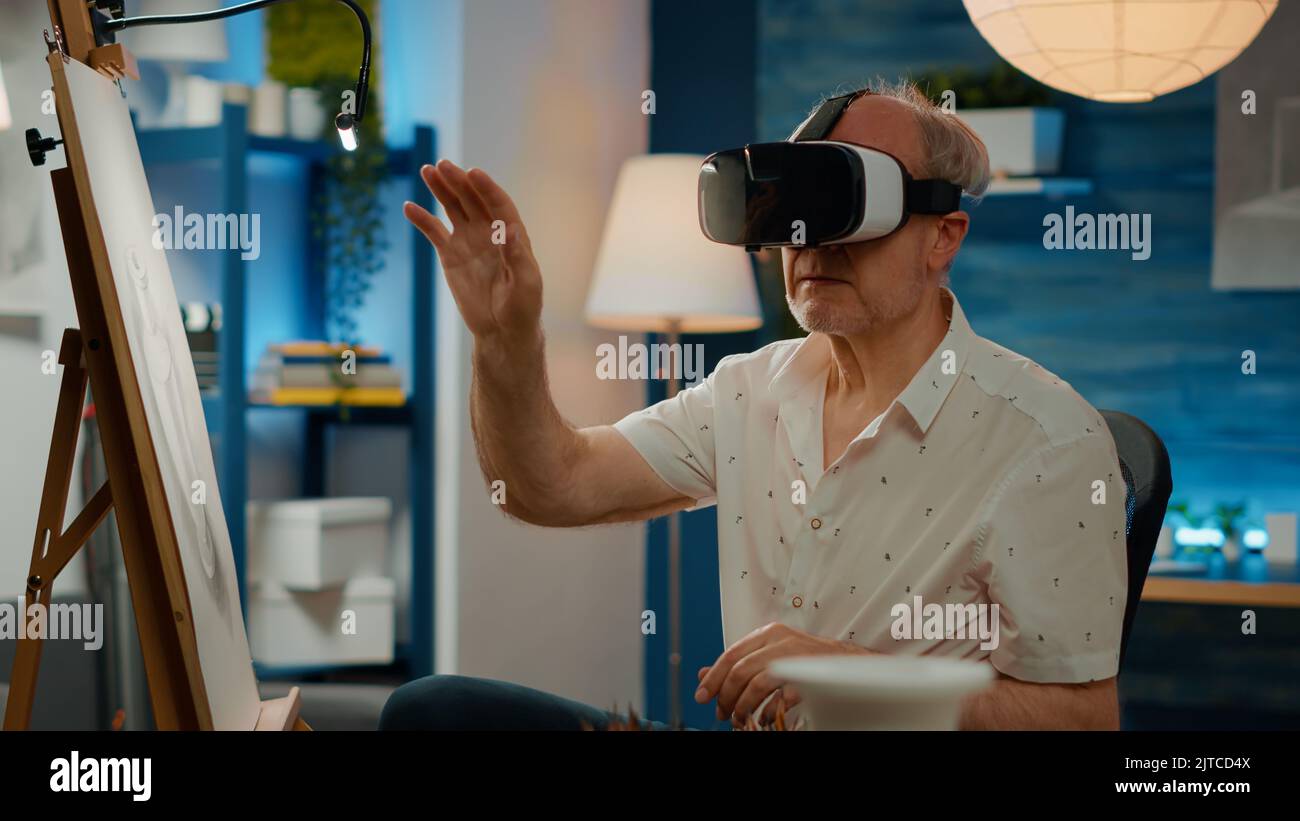 Senior man with creative skills drawing artwork using vr glasses and ...