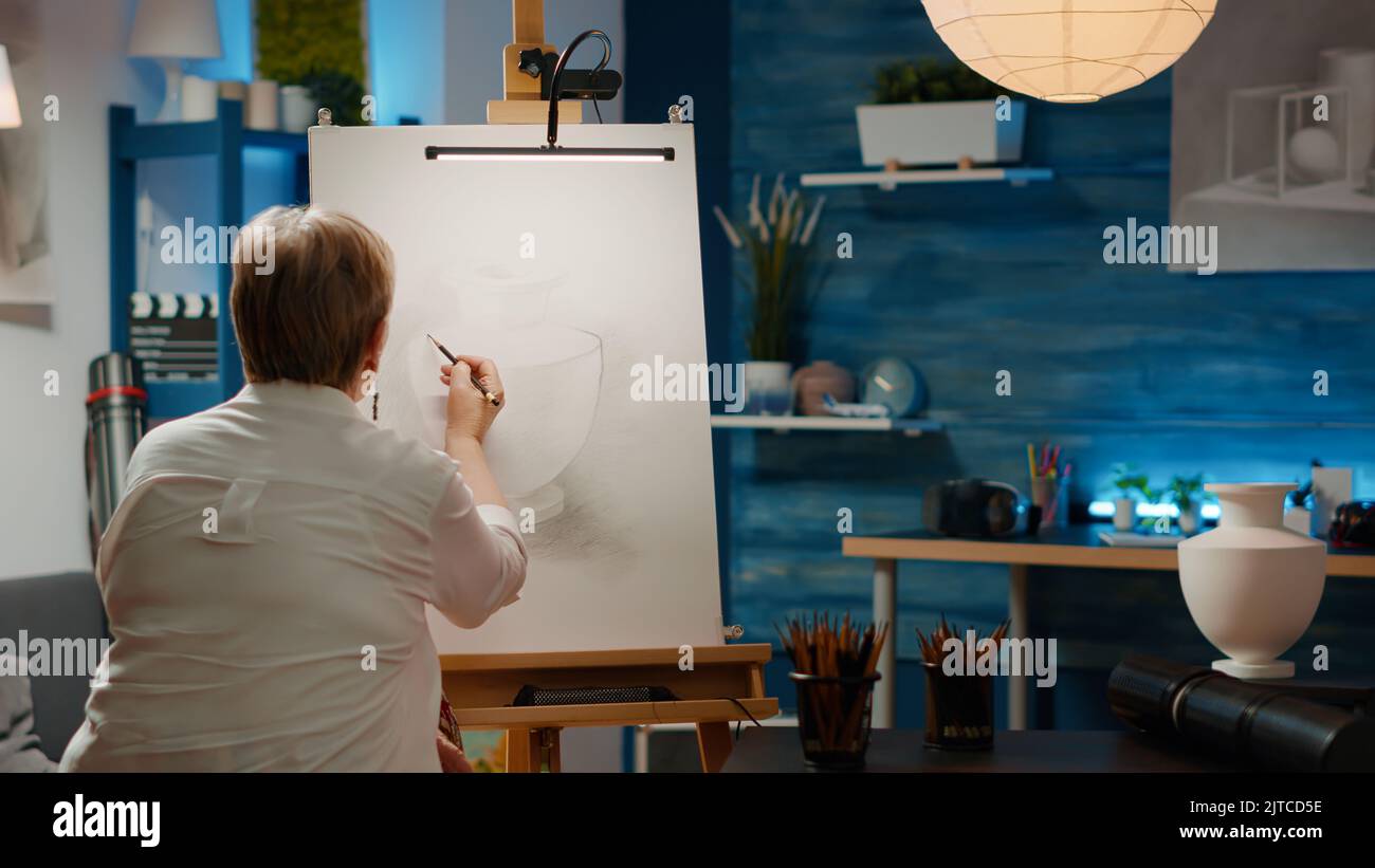 Old person with artistic skills drawing professional sketch of vase ...
