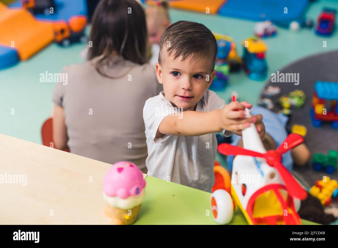 Nursery school. Toddlers on the floor playing with different plastic ...