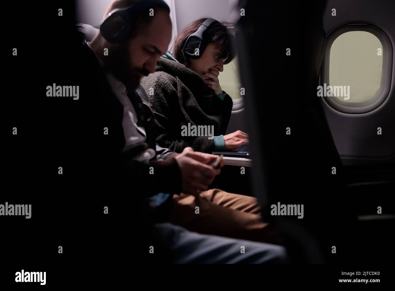 Group of passengers flying together on plane in economy class ...