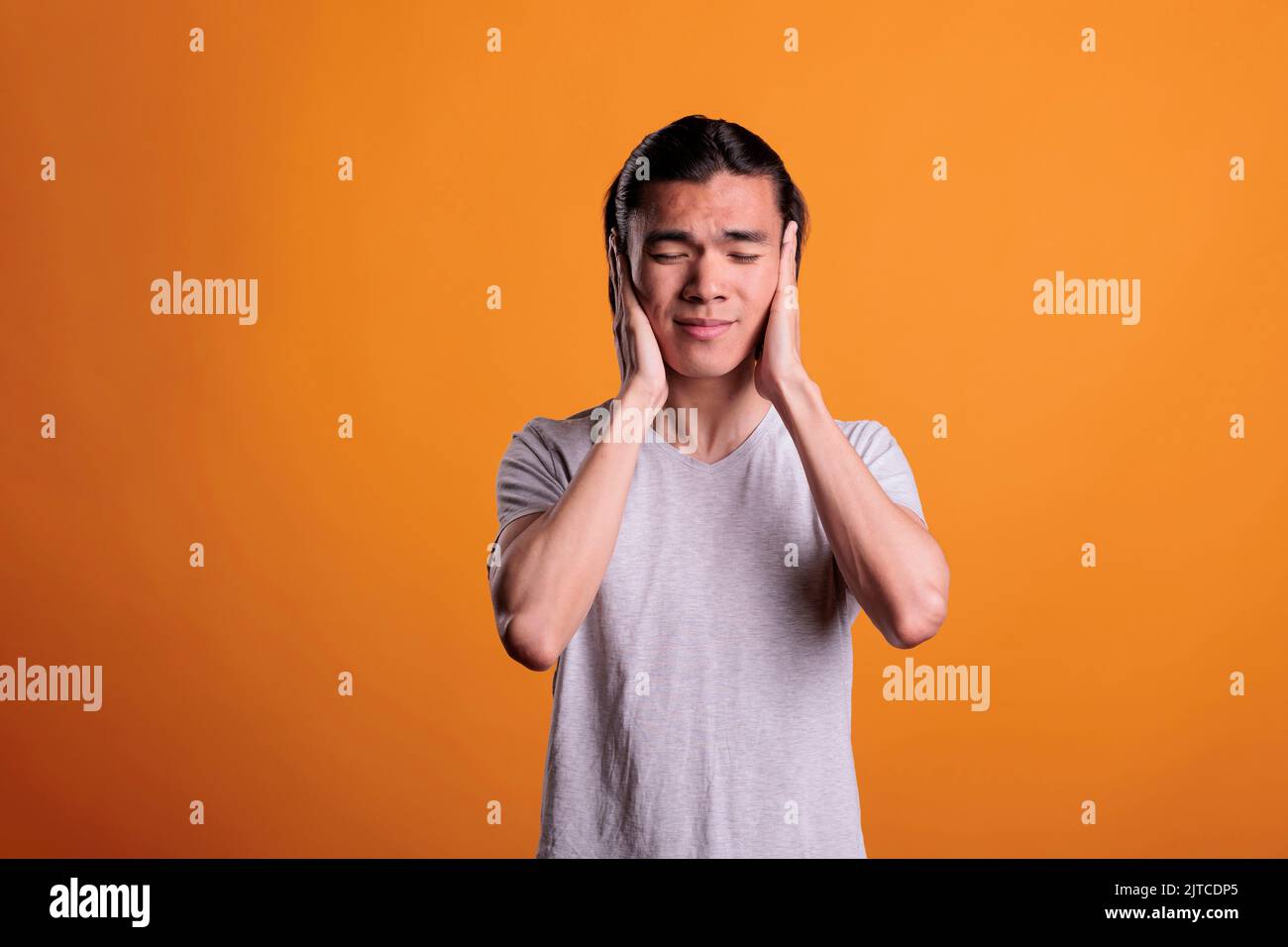 Young man covering ears with hands, hear no evil, three wise monkeys ...