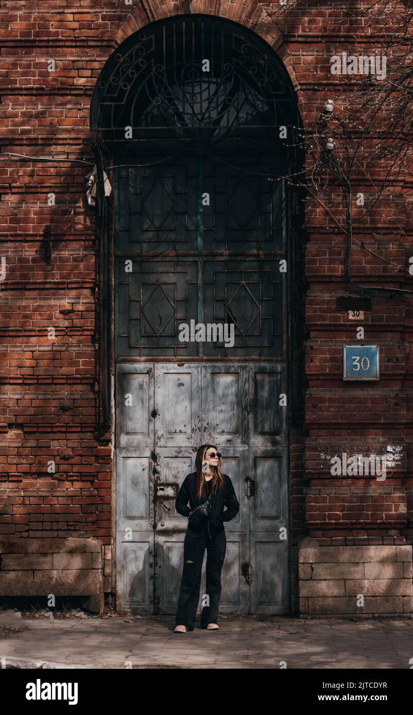 a young girl stands near an old building Stock Photo - Alamy