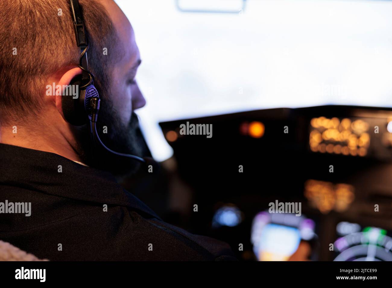 Male pilot using airplane cockpit command to fly jet, pushing dashboard ...