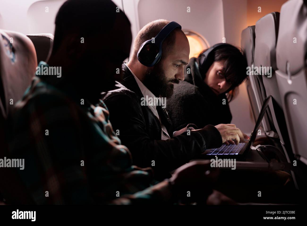Group of tourists travelling on commercial flight by airplane, being ...
