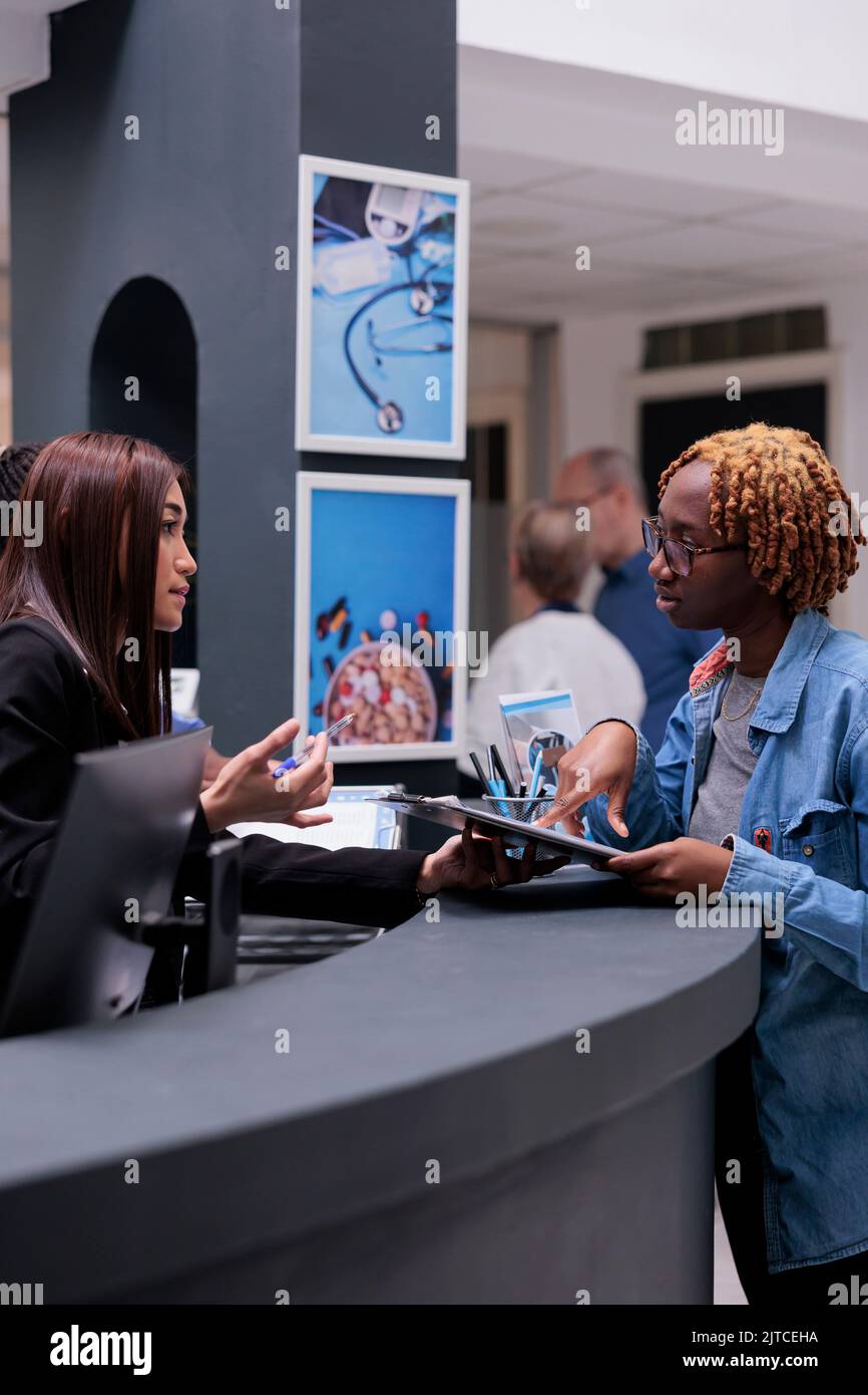 Receptionist doctor helping old hi-res stock photography and images - Alamy