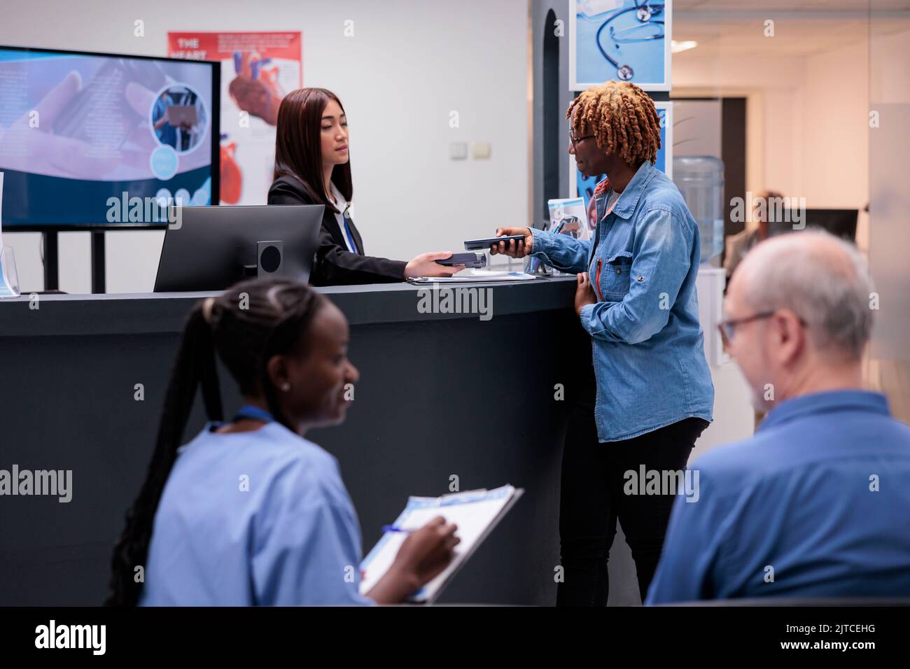 African american woman paying appointment with credit card transaction ...