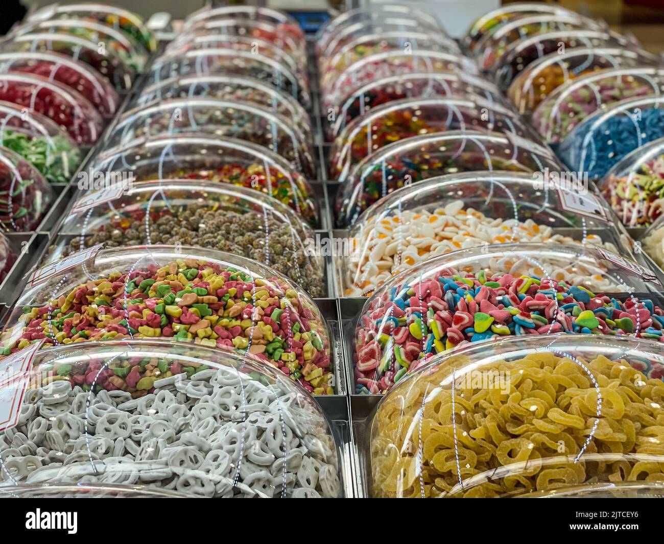 Rows of colorful, sugary sweets sit on display in plastic containers at ...