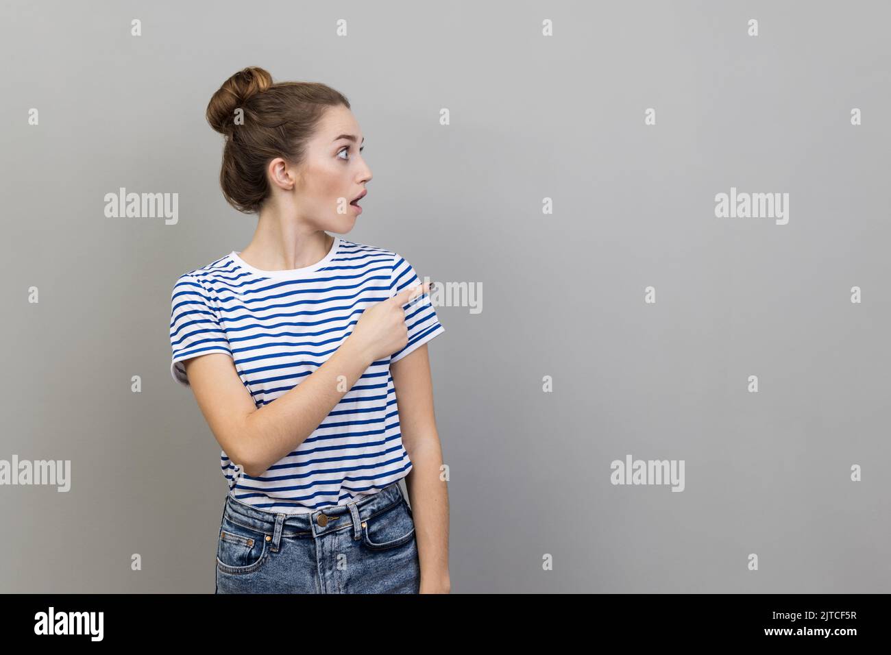 Wow, look at ads here. Portrait of astonished woman in striped T-shirt ...