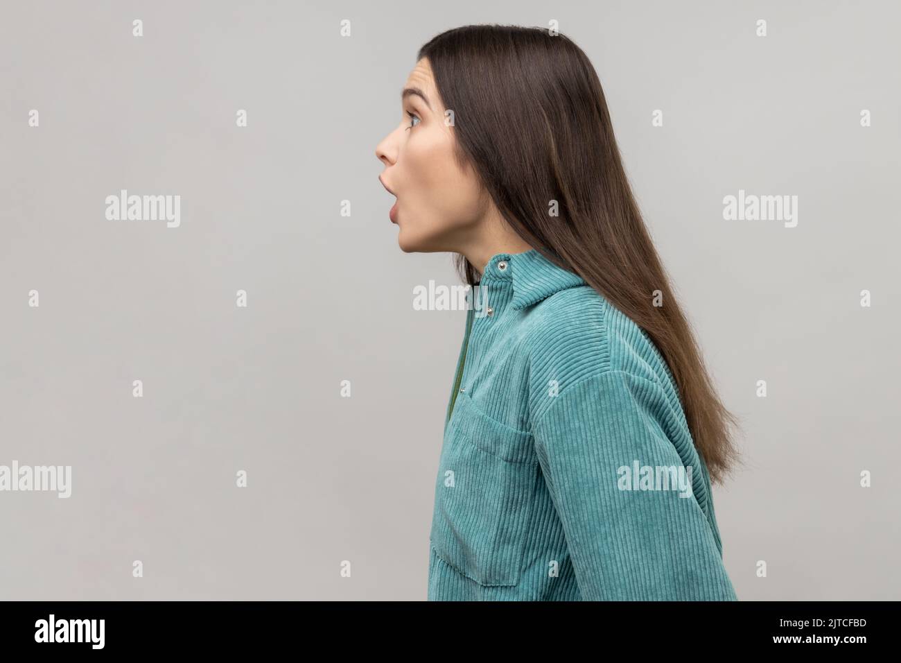 Side view of astonished woman with widely open mouth in amazement and ...