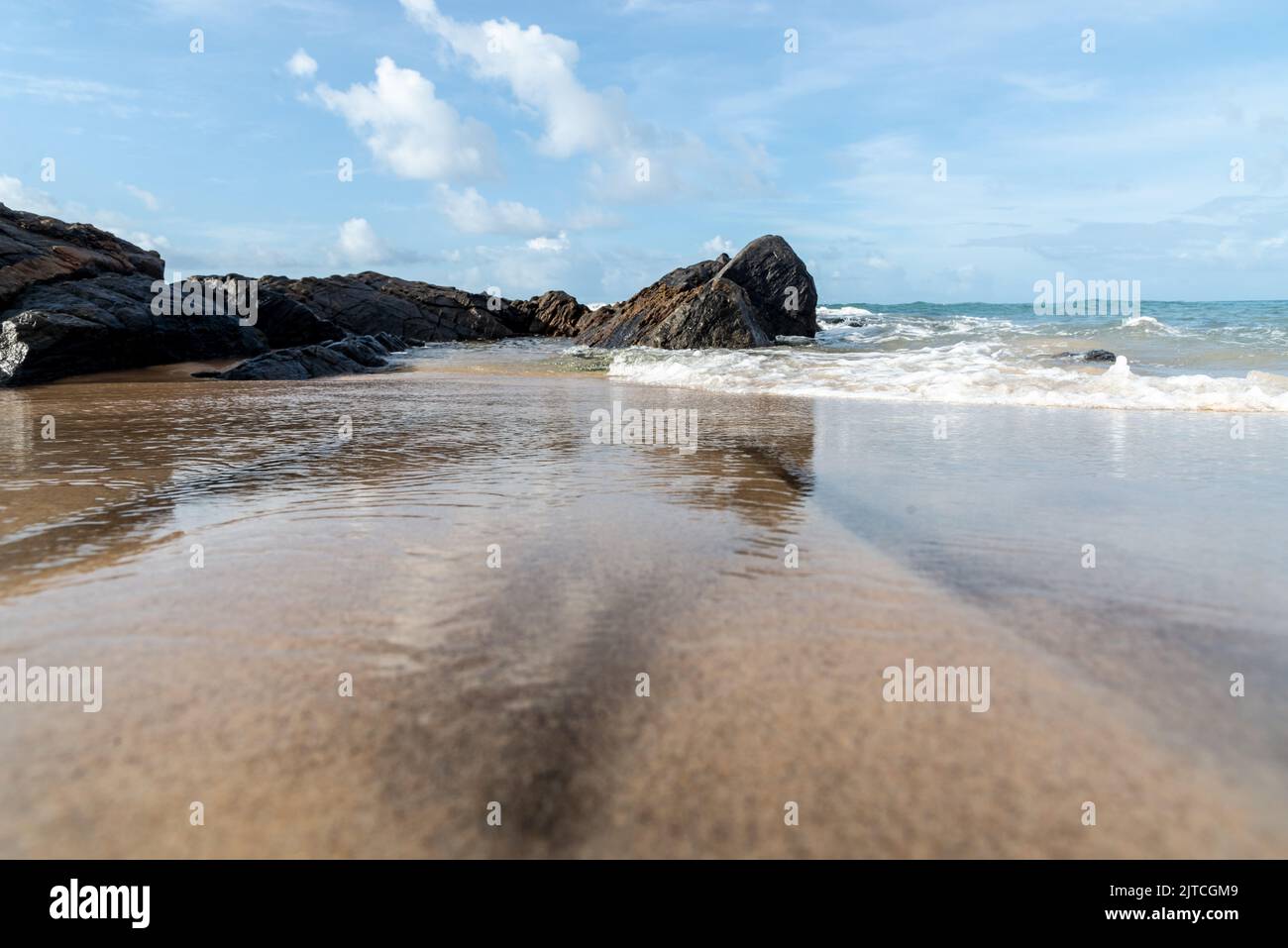 A wave breaks about a rock during a curtain on the sea. Farol da Barra ...
