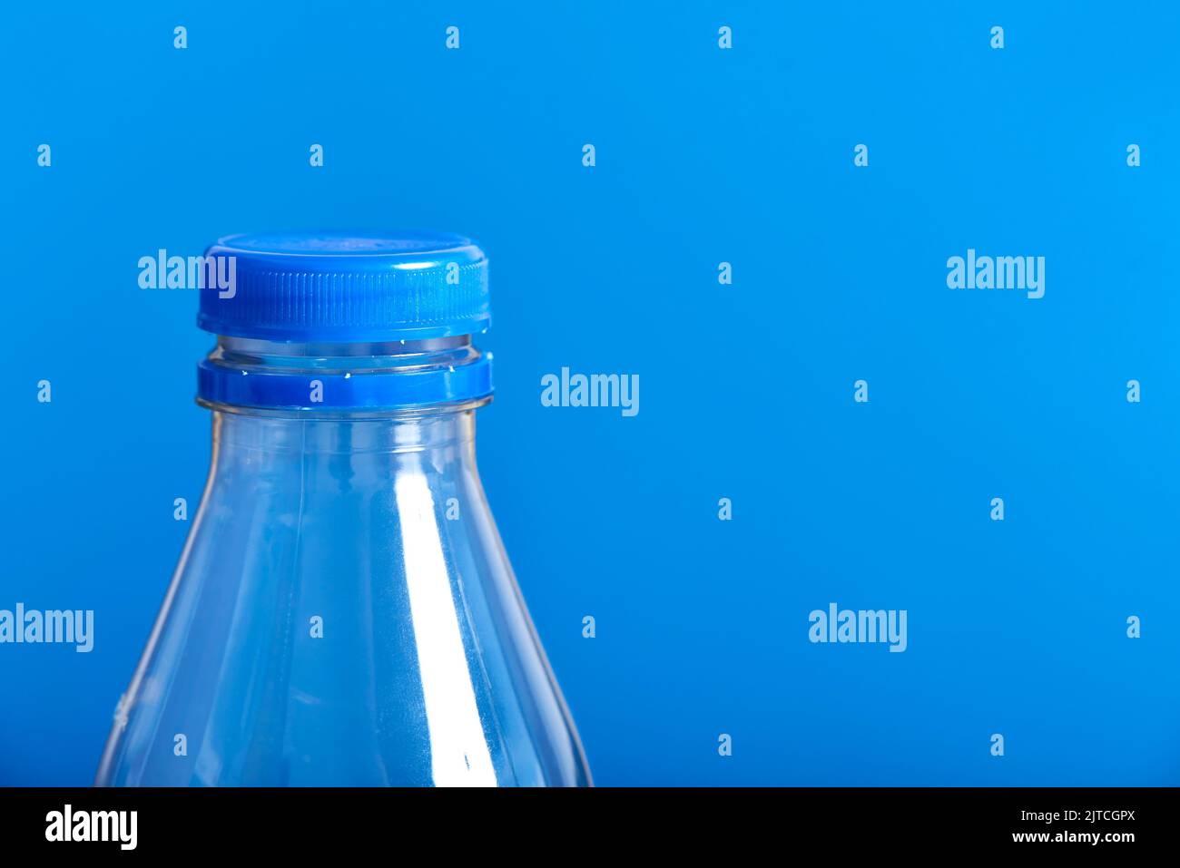 Top of an empty plastic transparent disposable bottle with blue cap and ...