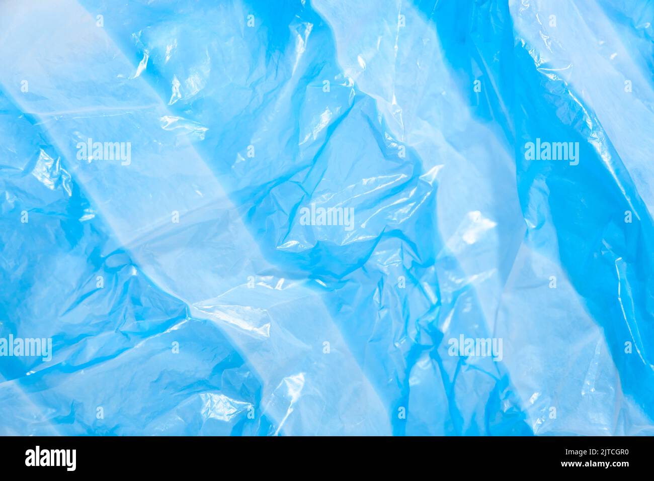 Blue plastic background, striped single use bag. Concepts ...