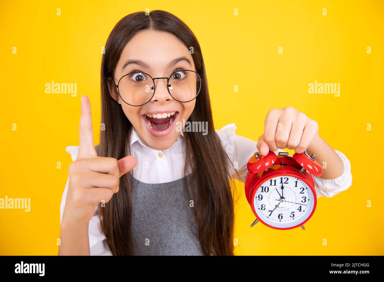Portrait of teenage girl with clock alrm, time and deadline. Studio ...