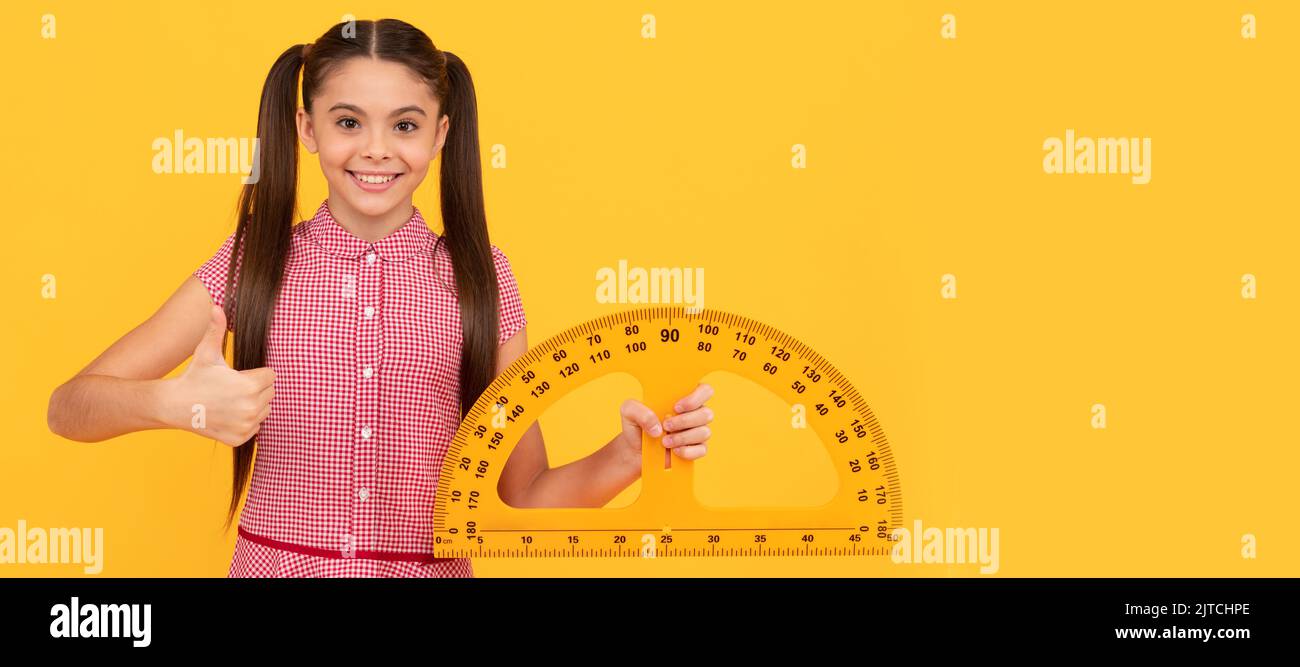 happy child hold school math tool protractor ruler on yellow background ...
