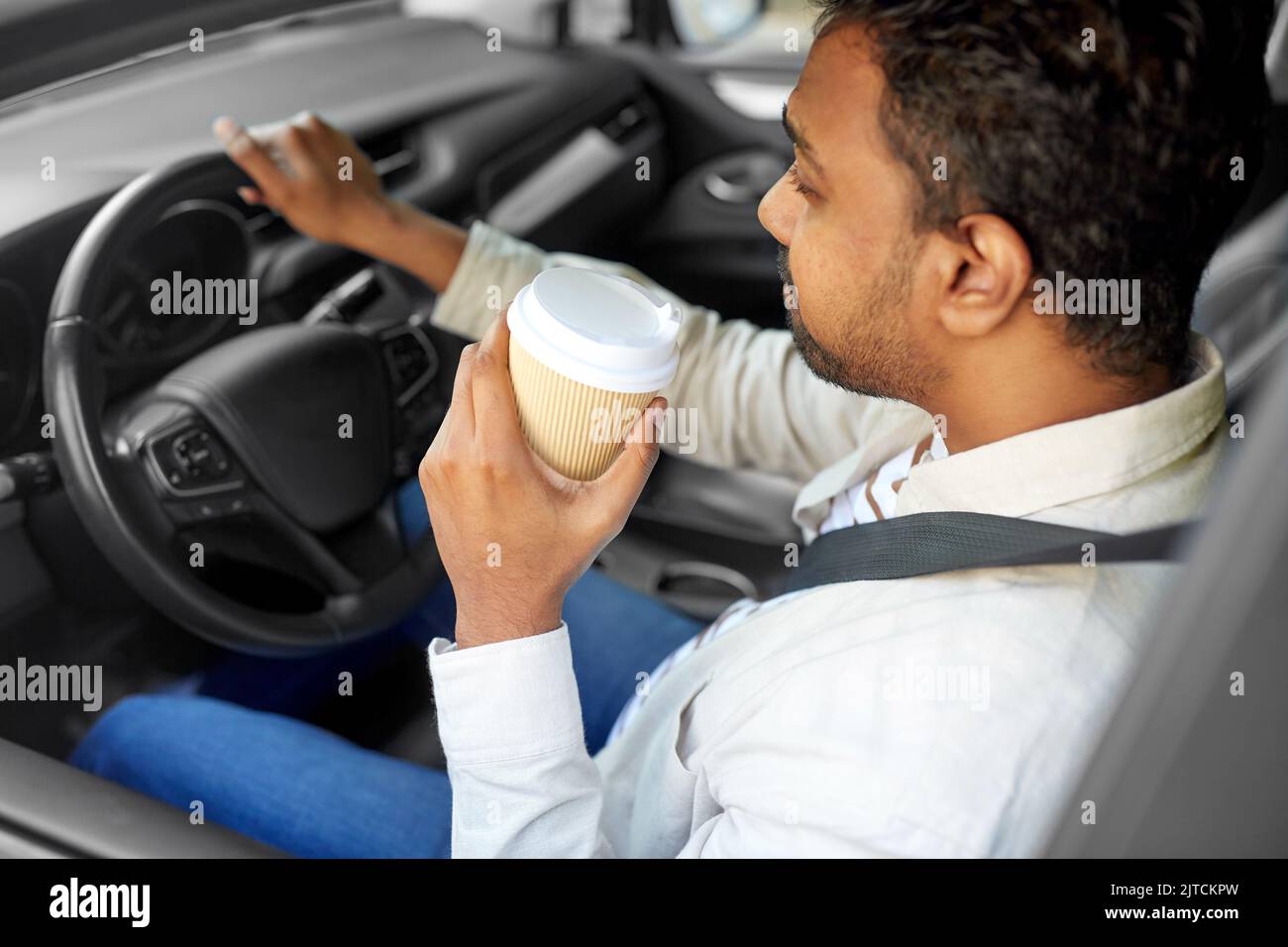 tired indian man or driver with coffee driving car Stock Photo - Alamy