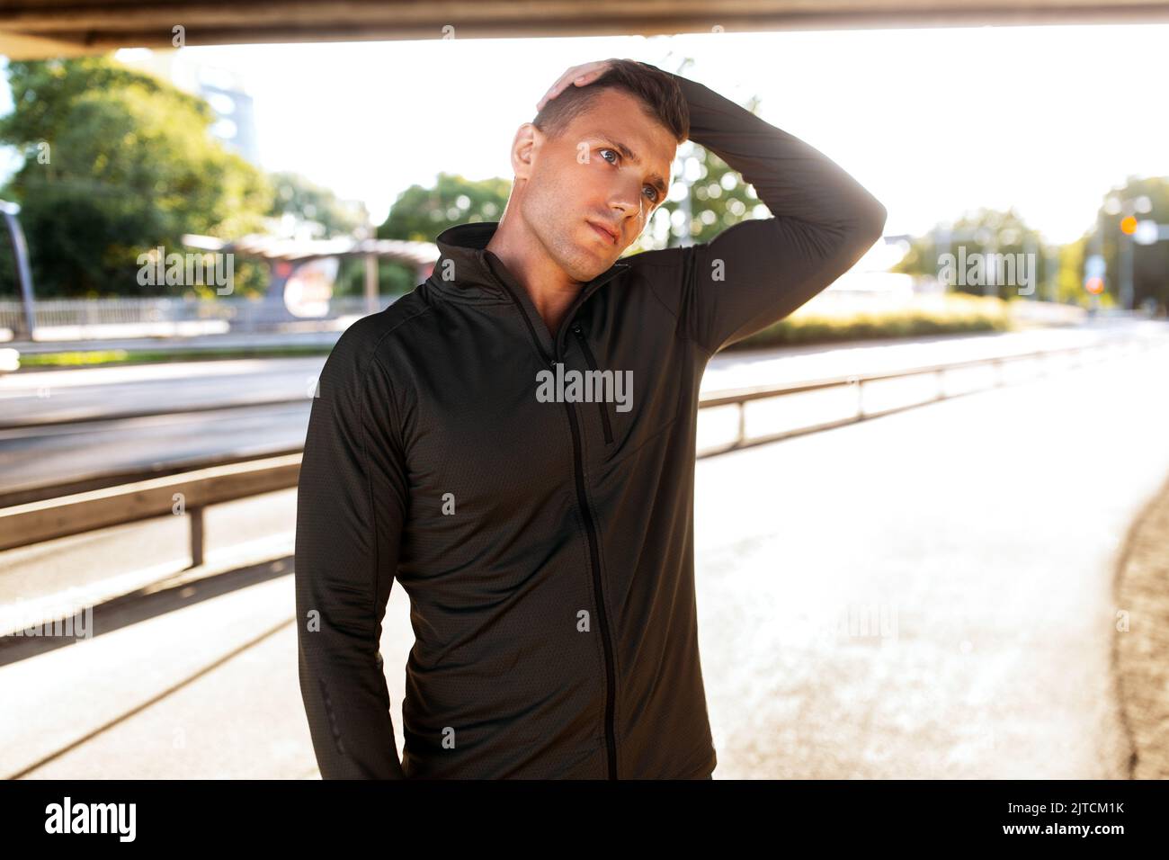man stretching neck under bridge Stock Photo - Alamy