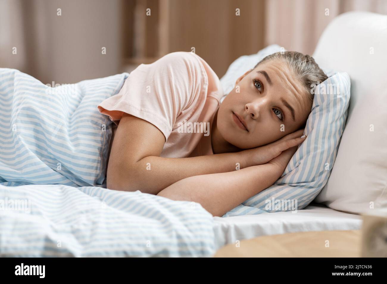 awake girl lying in bed at home Stock Photo - Alamy