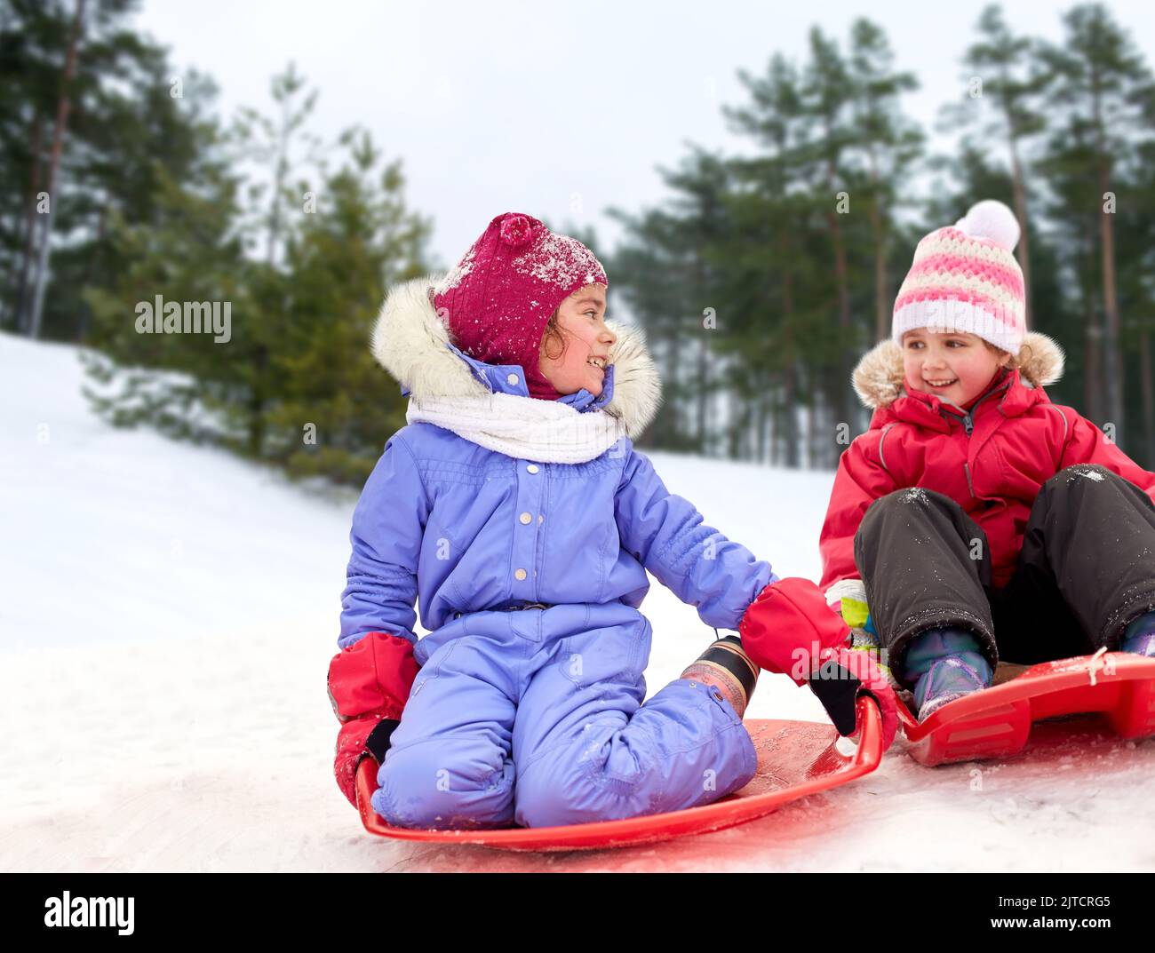 happy little girls on sleds outdoors in winter Stock Photo - Alamy