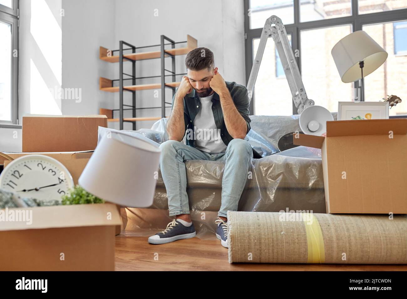 sad man with boxes moving to new home Stock Photo - Alamy