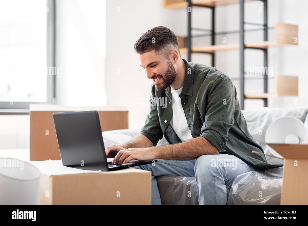 man with laptop computer and moving into new home Stock Photo - Alamy