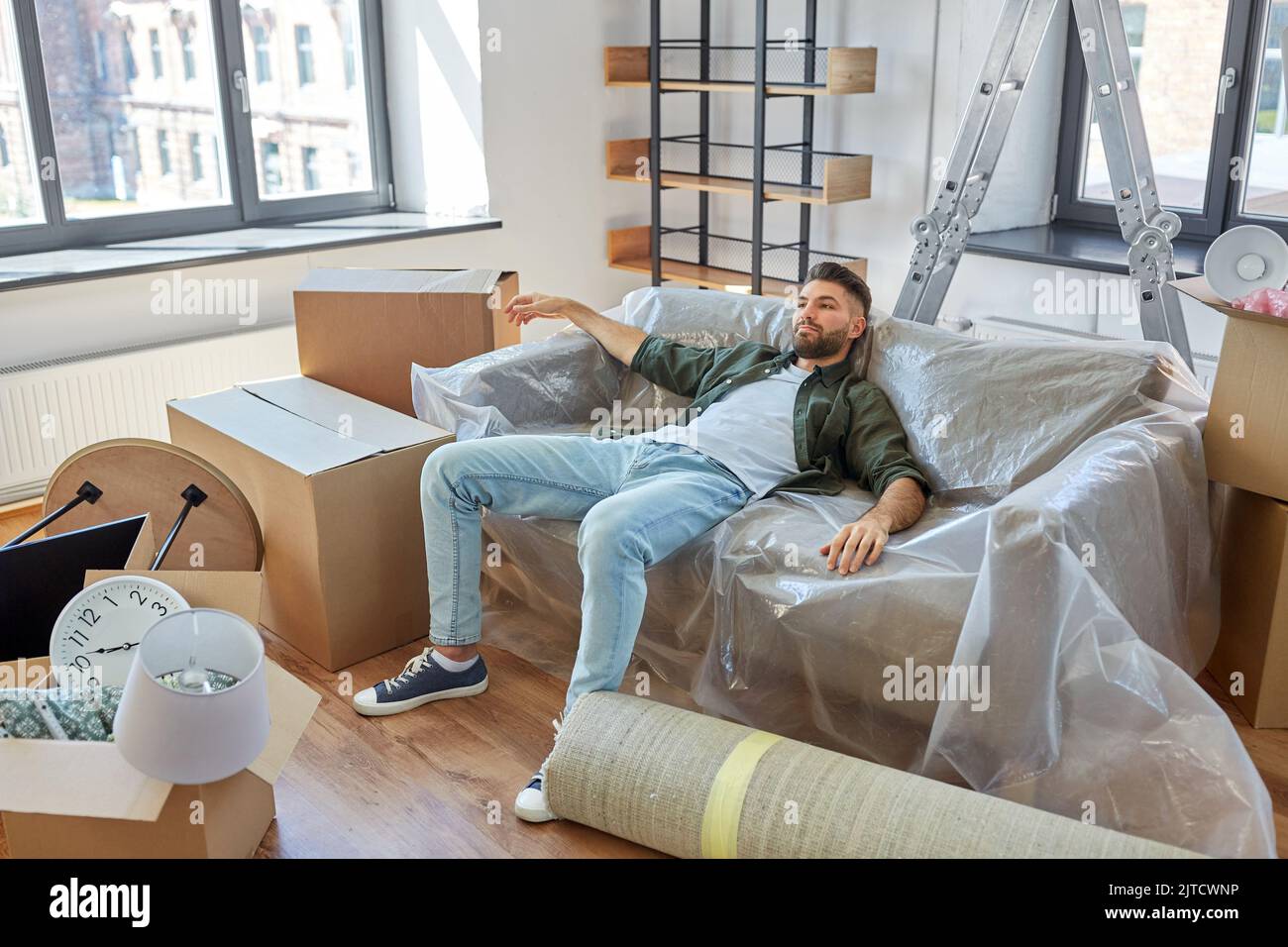 tired man with boxes moving to new home Stock Photo - Alamy