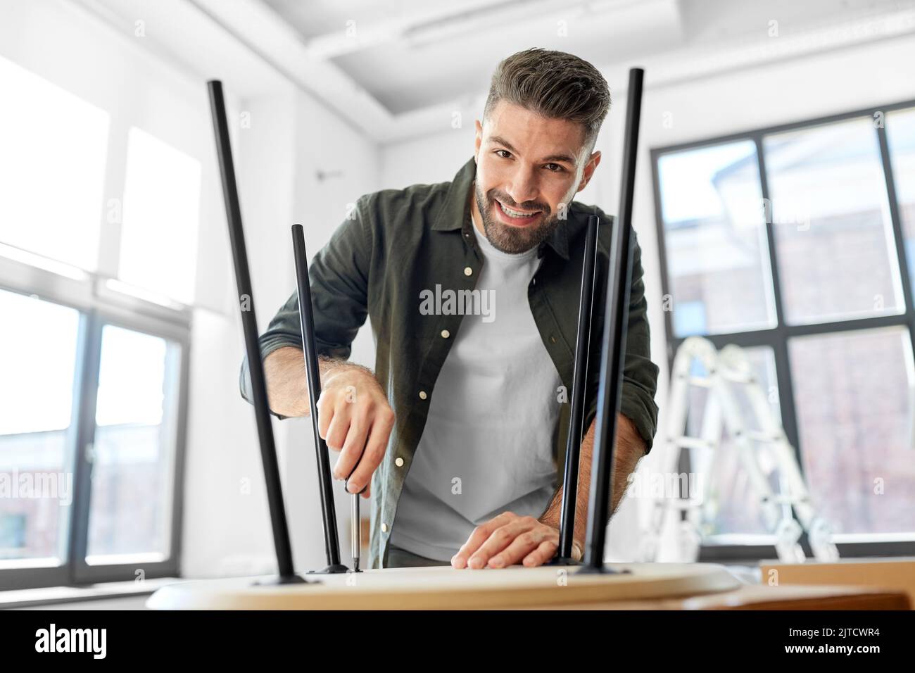 happy man assembling coffee table at new home Stock Photo - Alamy