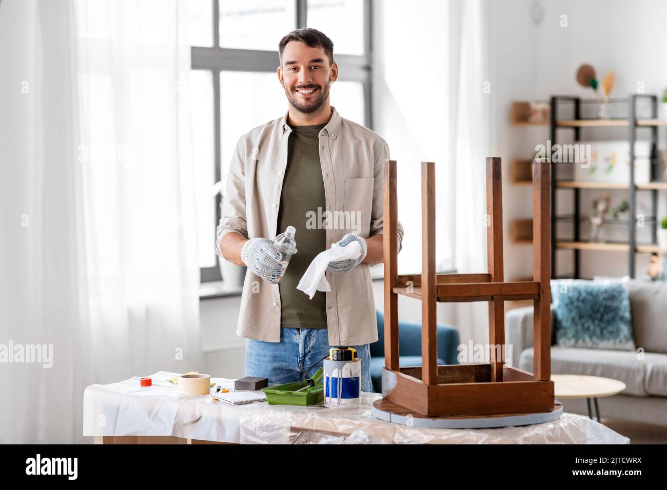 man applying solvent to rag for cleaning old table Stock Photo - Alamy