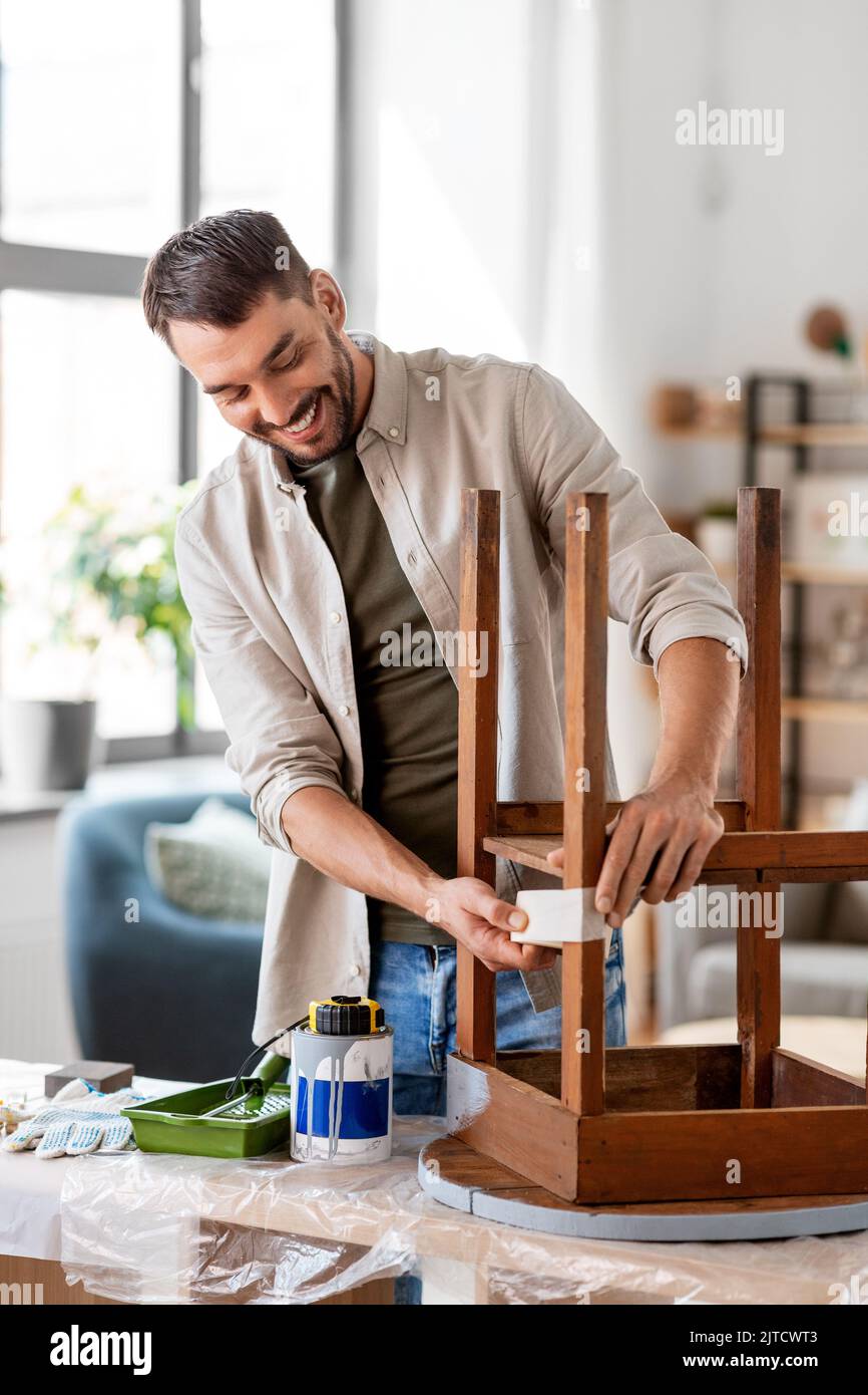 man sticking adhesive tape to table for repainting Stock Photo - Alamy