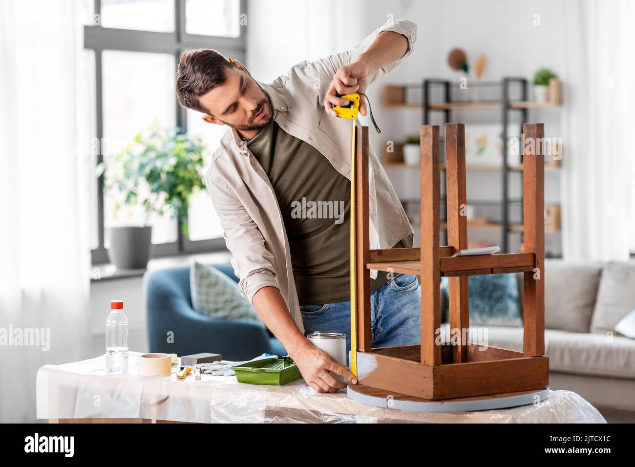 man with ruler measuring table for renovation Stock Photo - Alamy