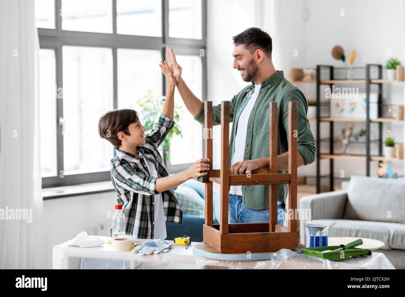 father and son making high five and restore table Stock Photo - Alamy