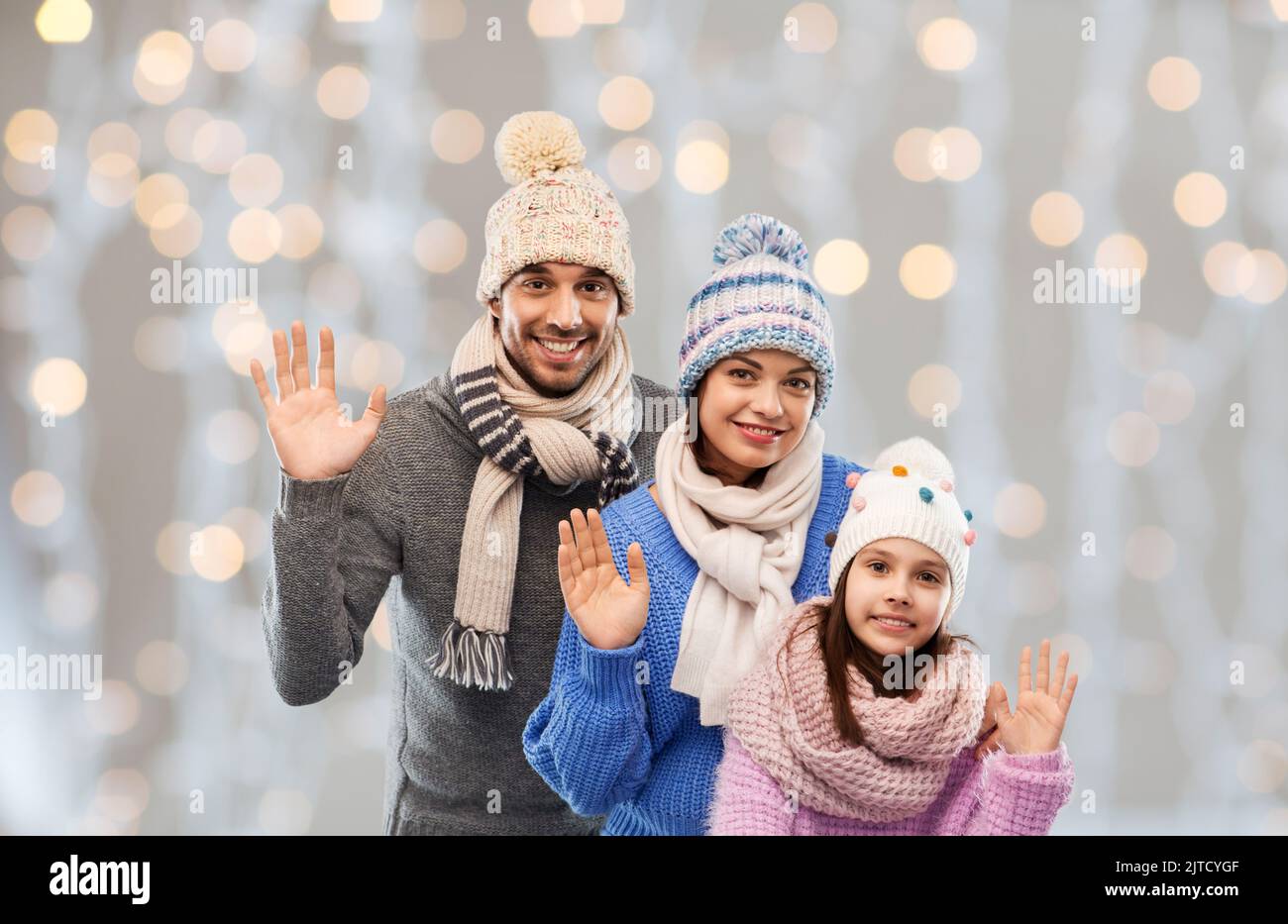 happy family in winter clothes waving hands Stock Photo - Alamy
