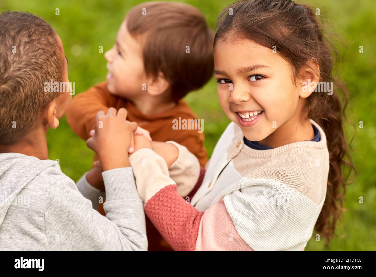 happy children playing and stacking hands at park Stock Photo - Alamy