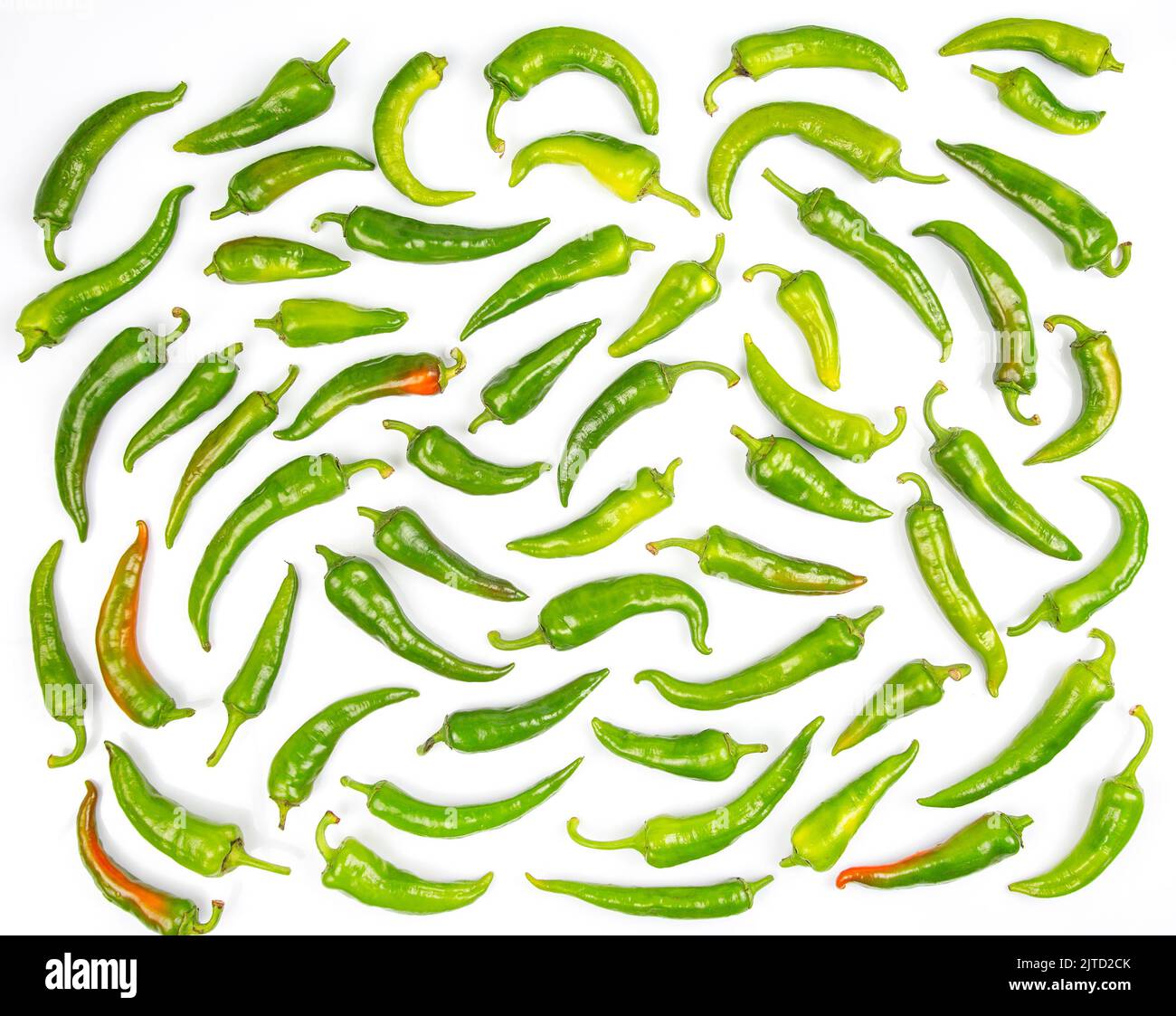 green hot peppers evenly spread on a white background. vitamin ...