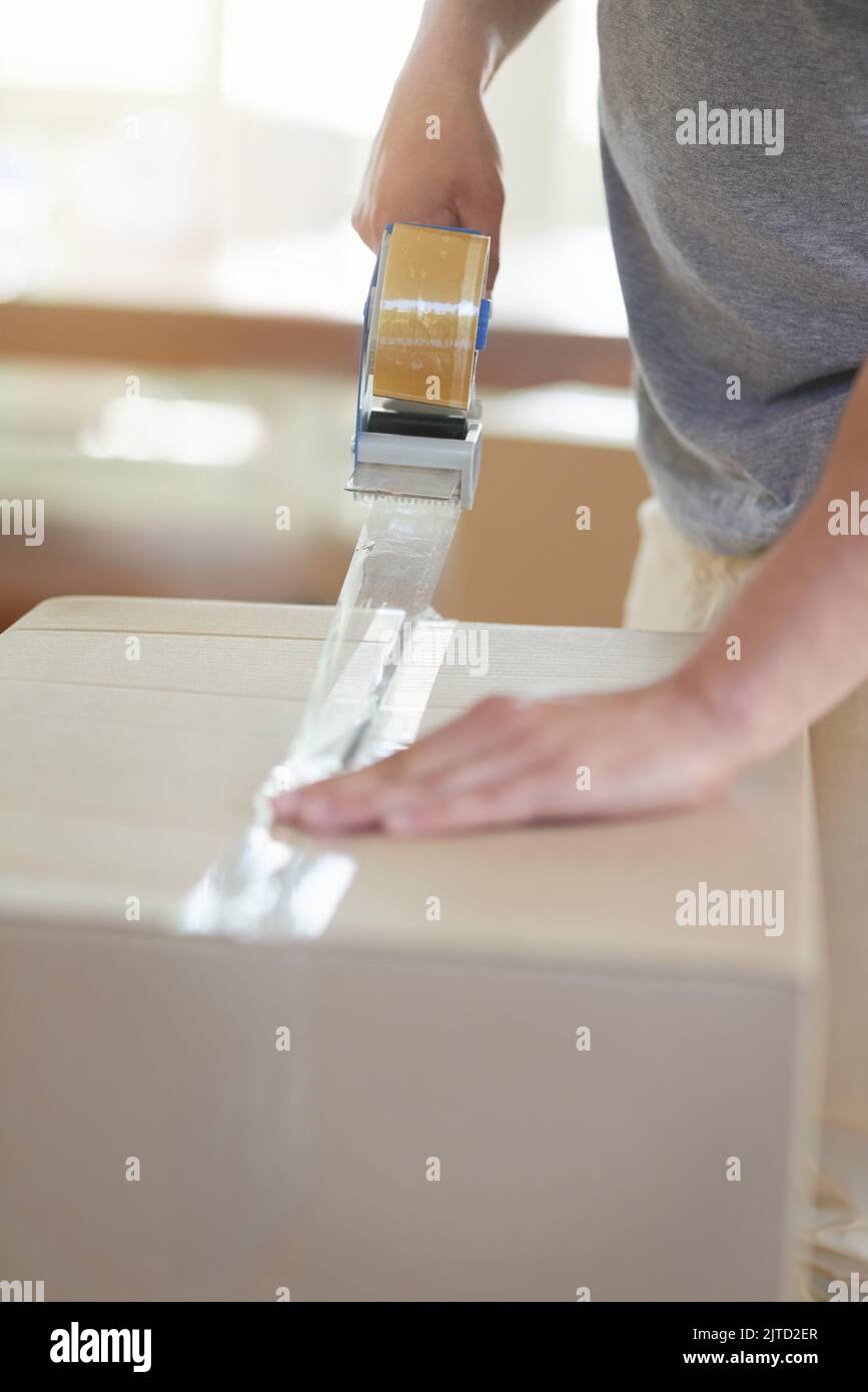 Boxing it all up. an unidentifiable young man closing a cardboard box ...