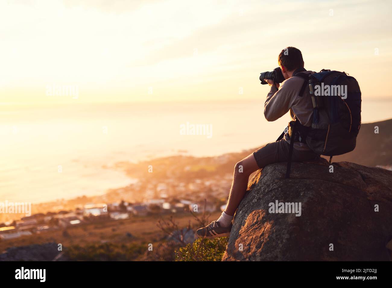 Picture perfect. a young photographer taking a picture from the top of a mountain Stock Photo ...