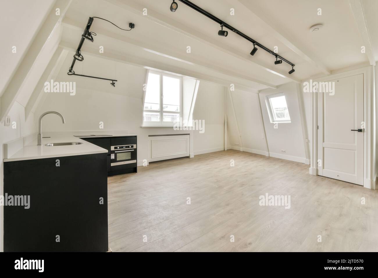 Interior of empty white kitchen with corridor and wooden parquet floor ...
