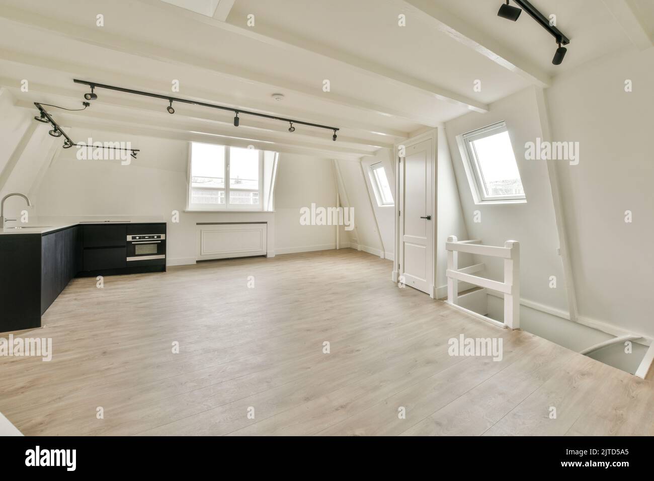 Interior of empty white kitchen with corridor and wooden parquet floor ...