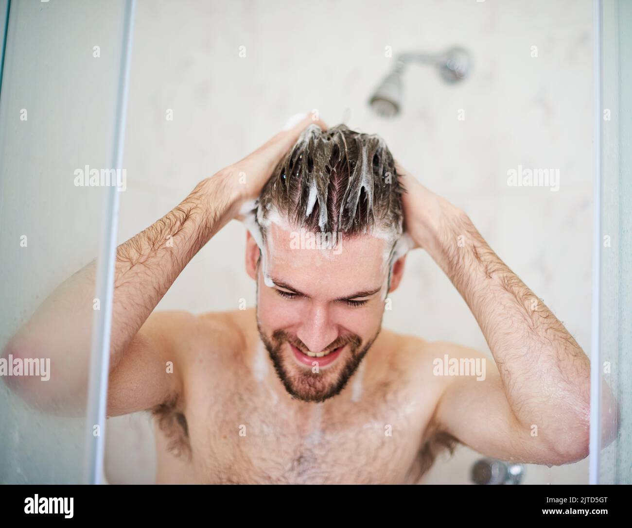 Shampoo and condition for a cleaner scalp. a handsome young man having ...