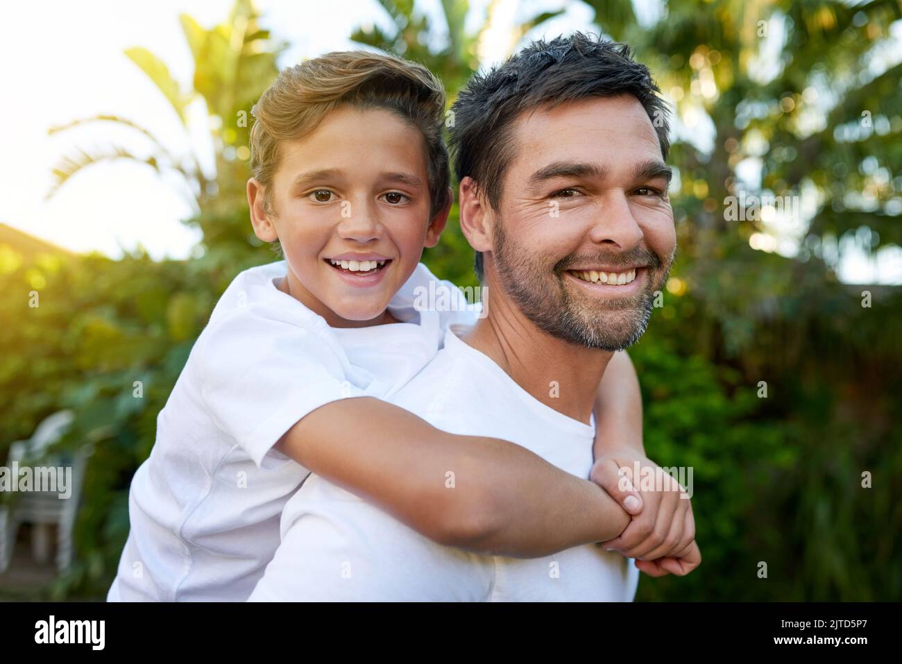 Enjoying the day with dad. Portrait of a father carrying his son on his ...