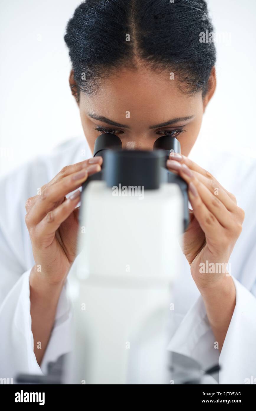 Taking a closer look. an attractive young female scientist working in ...