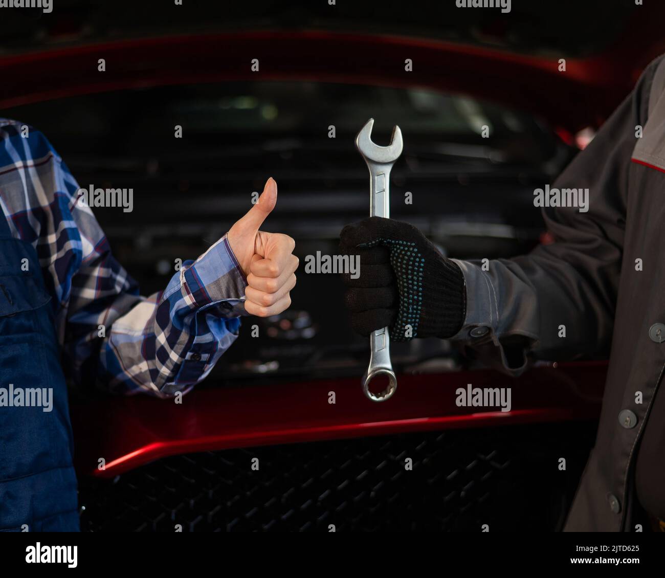 Close-up of woman's hand thumb up and mechanic's hand with tool ...