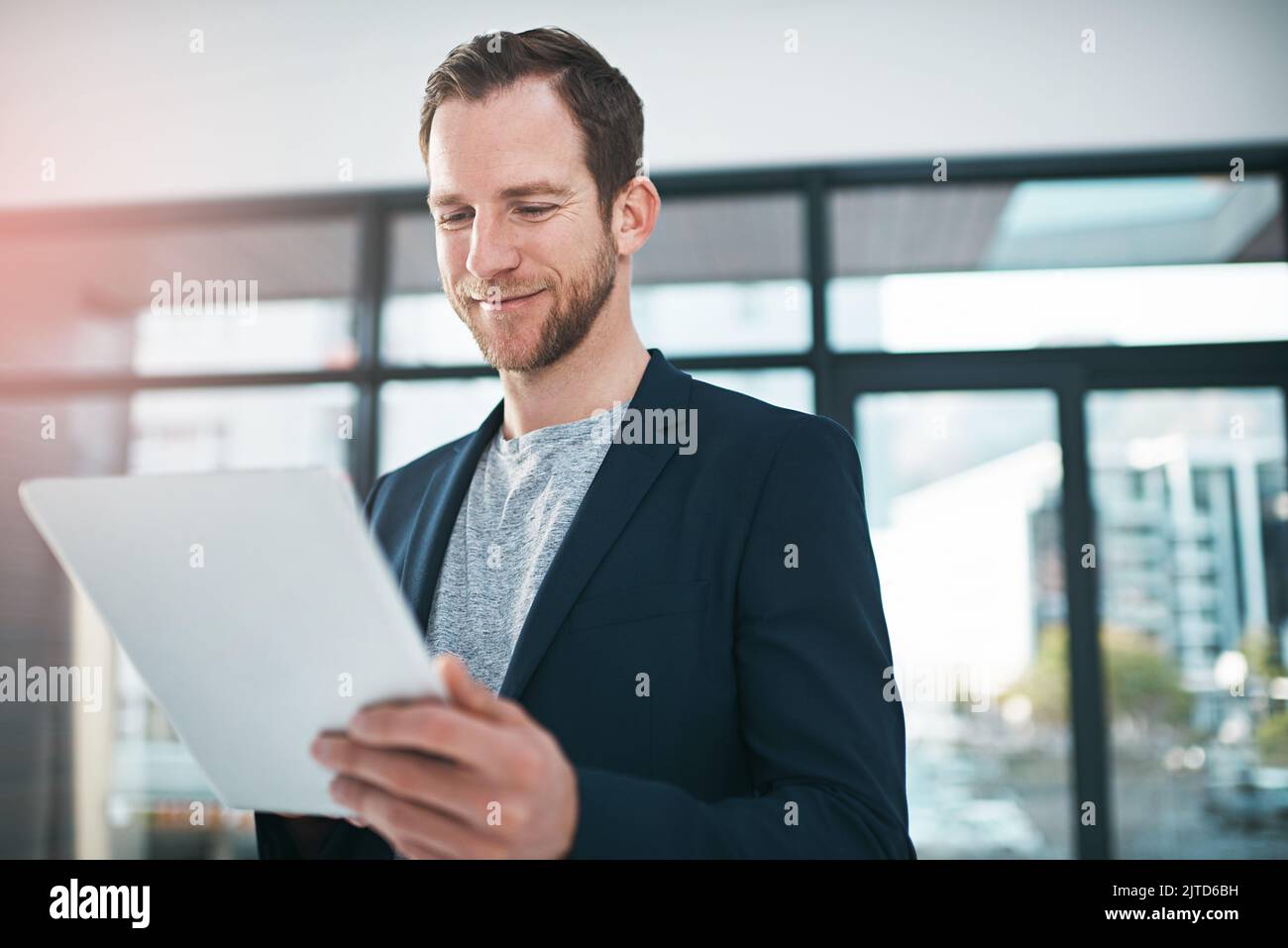 Putting progress first. a successful businessman using his tablet the ...
