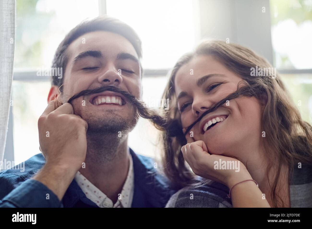 Show us your mo. a young couple enjoying a silly moment together while ...