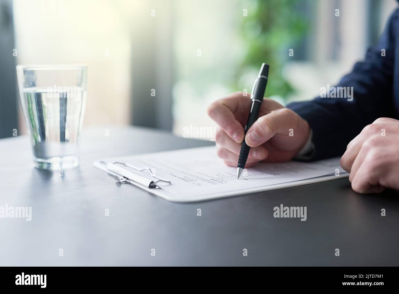 Think twice, check once. a businessman filling out paperwork on a ...